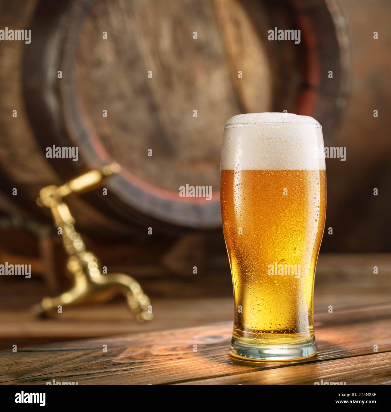 Glass of chilled beer and wooden beer cask at the background Stock ...