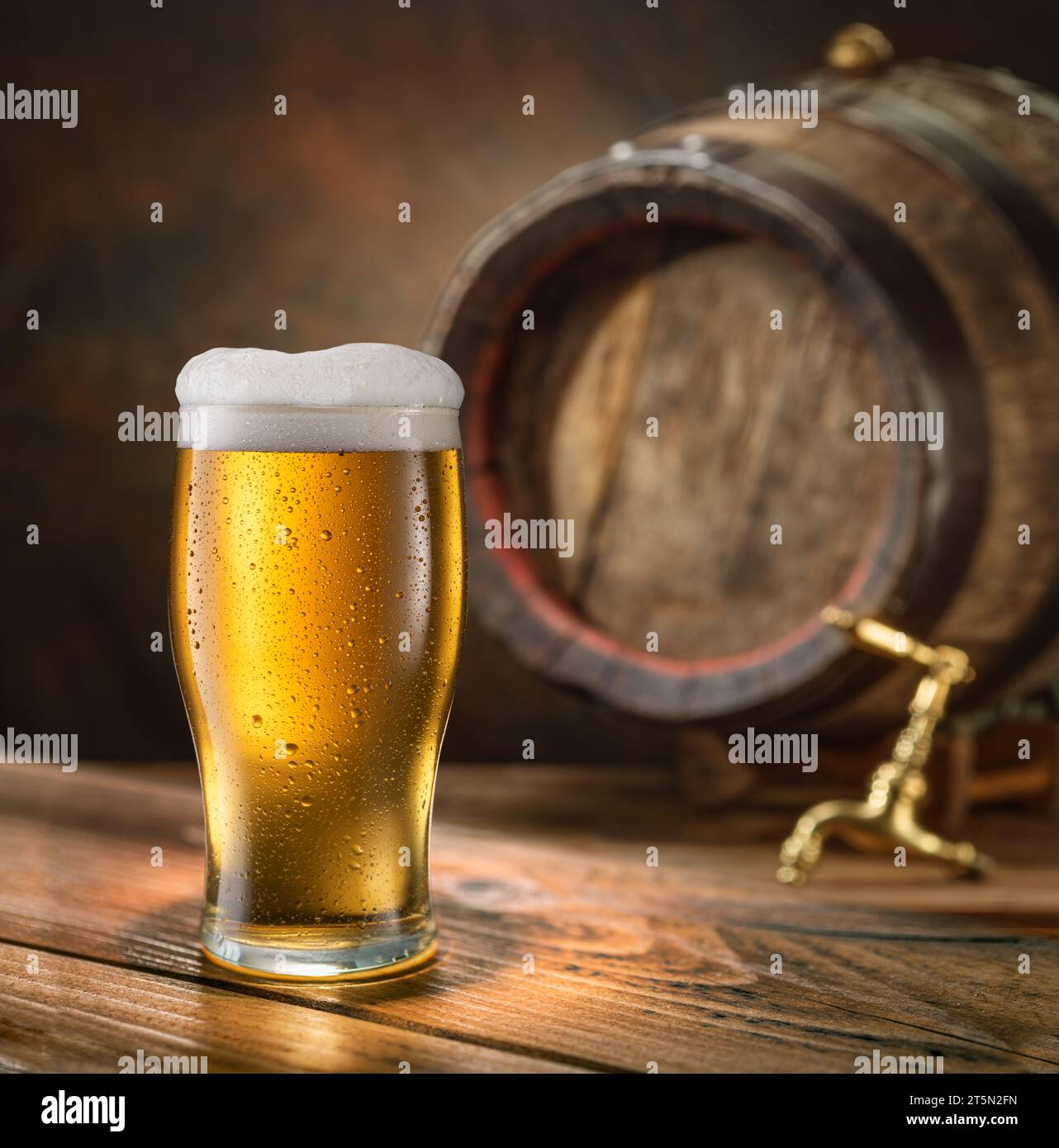 Glass of chilled beer and wooden beer cask on the background Stock ...