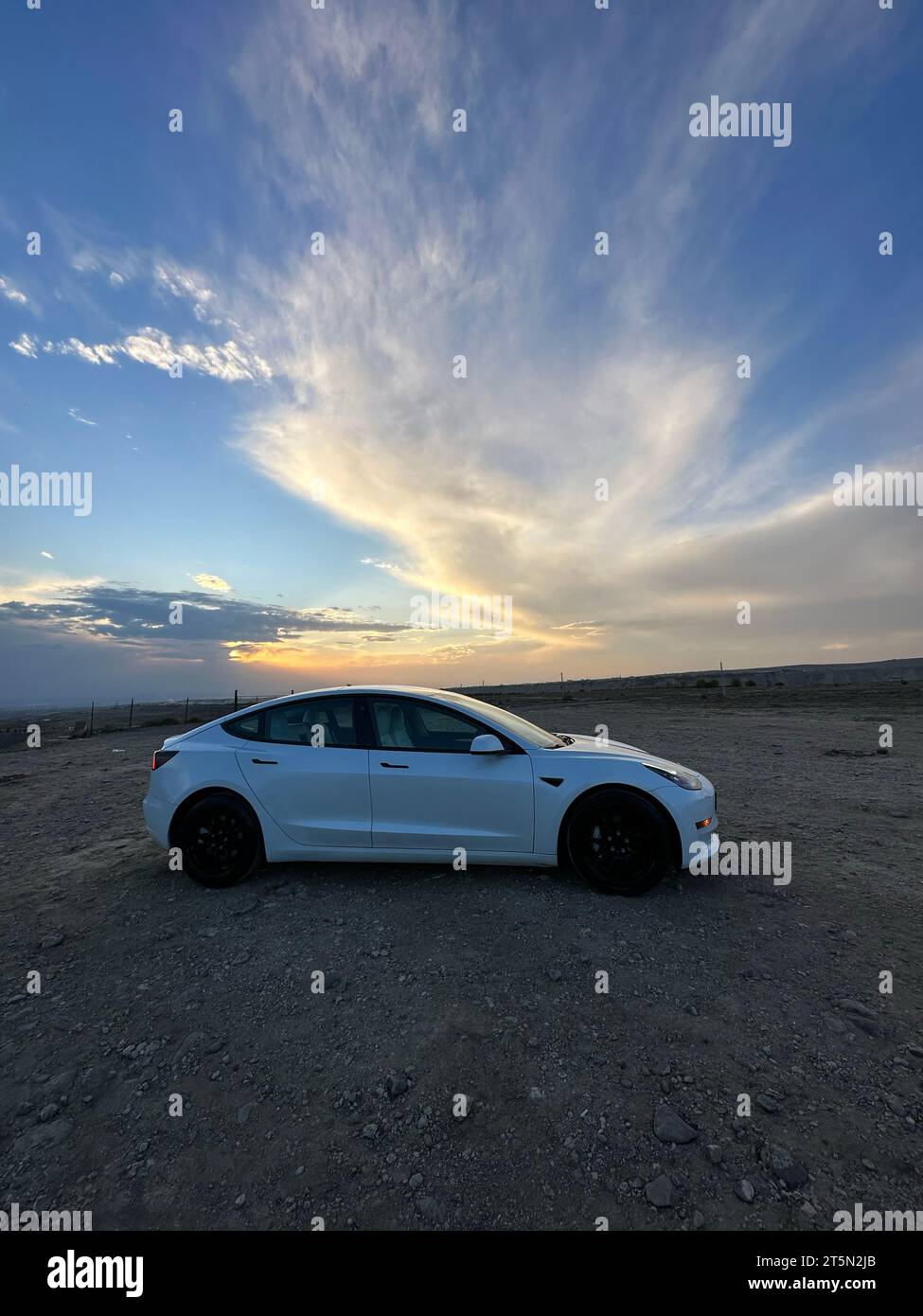 A white Tesla model 3 parked outdoors at sunset Stock Photo - Alamy