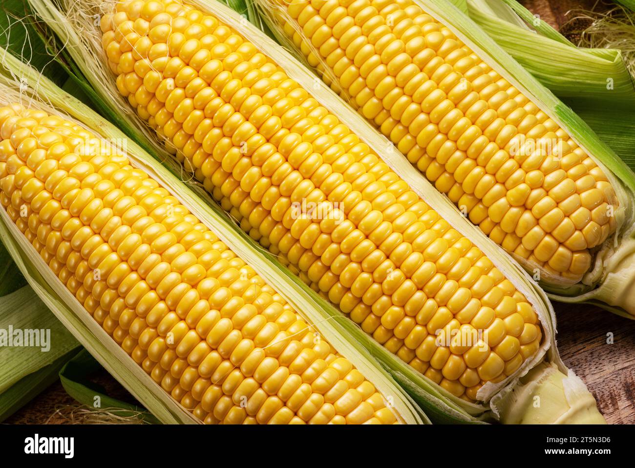 Ripe corn heads with corn whiskers and leaves. Nice vegetable cooking ...