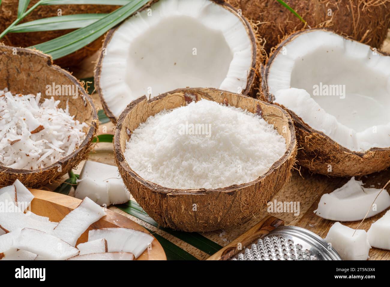 Fresh opened coconuts along with coconut slices, flakes and coconut ...