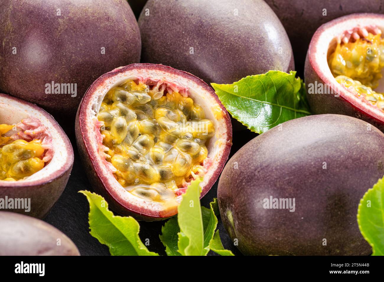 Ripe passion fruits with passion fruit seeds and passionfruit leaves on ...