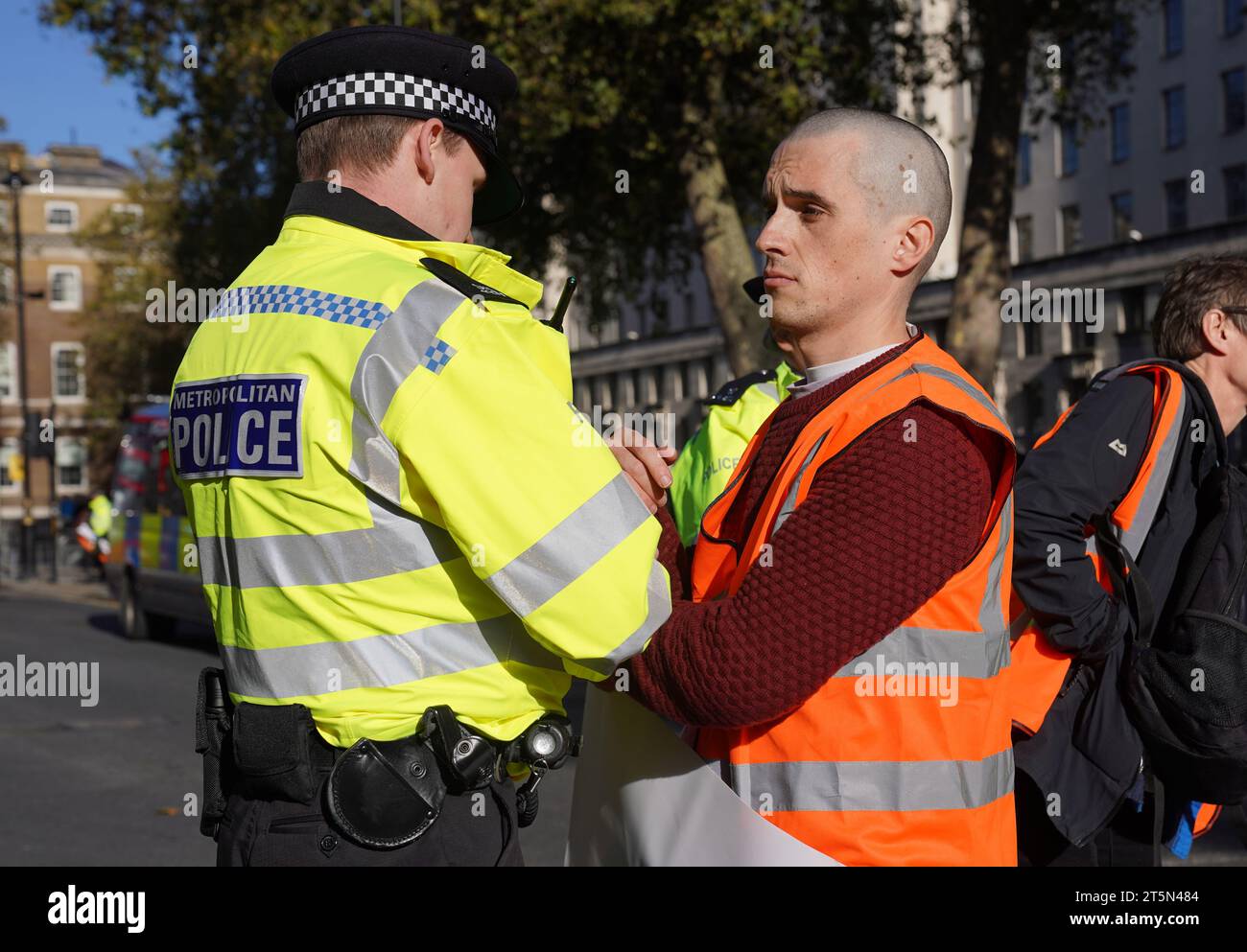 A Just Stop Oil protester is removed by a police officer whilst ...