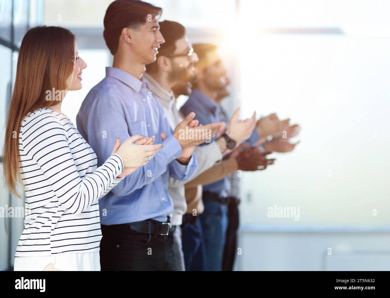 A group of people standing in a row clapping their hands Stock Photo ...