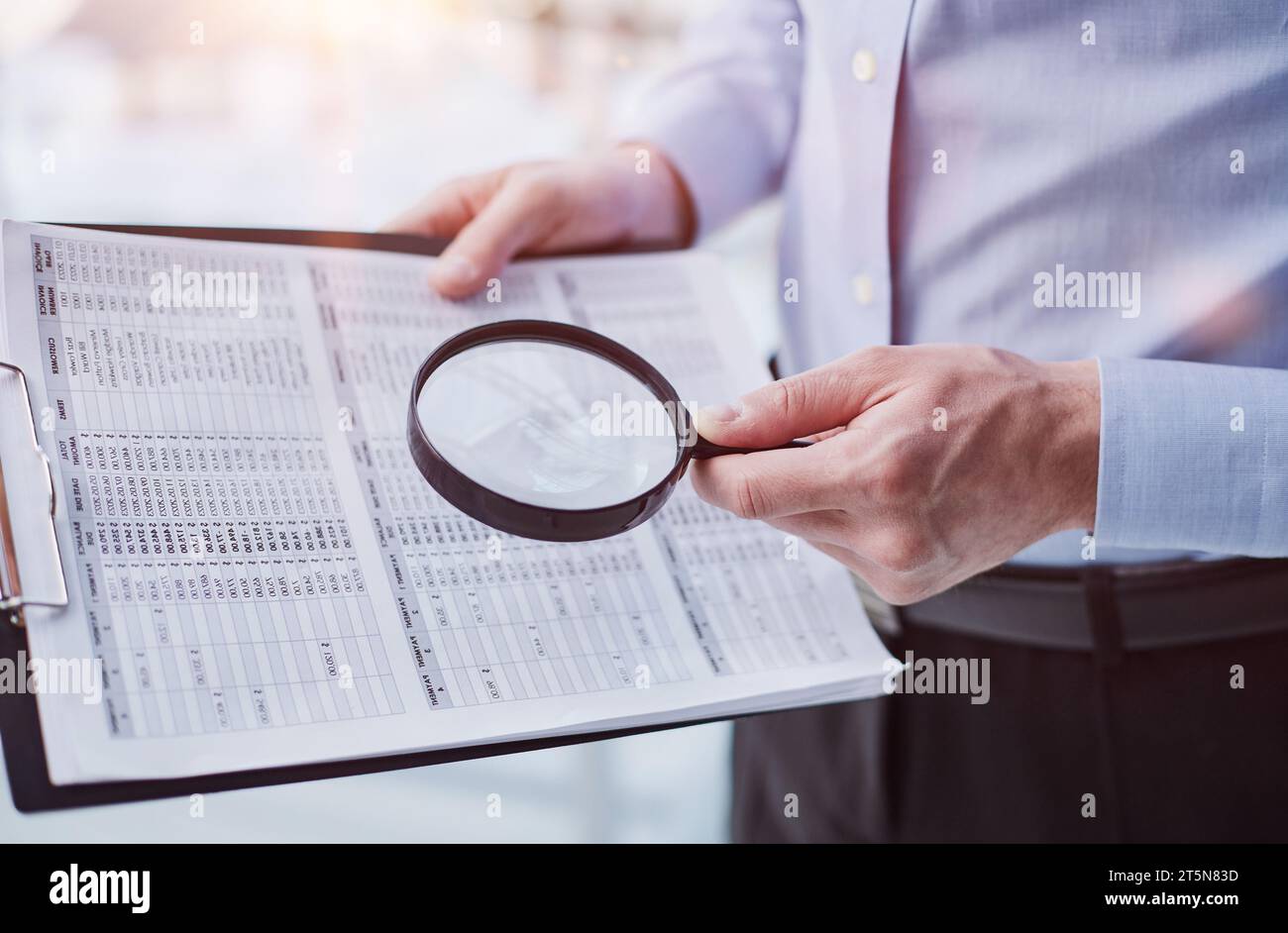 Businessman looking through a magnifying glass to documents Stock Photo ...