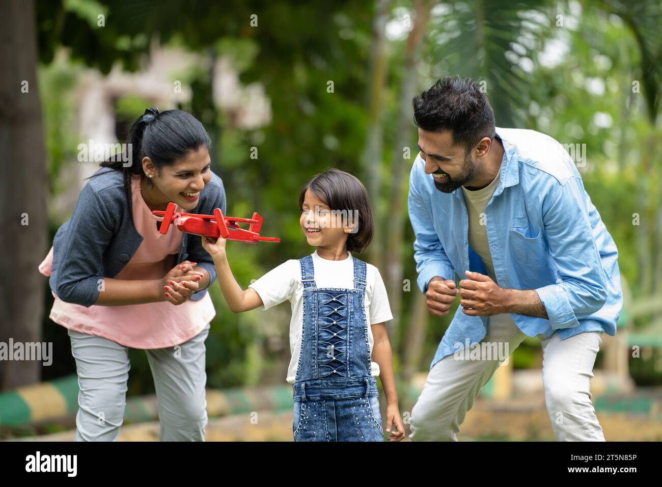 Tracking shot of excited Indian Parents running with girl kid while kid ...