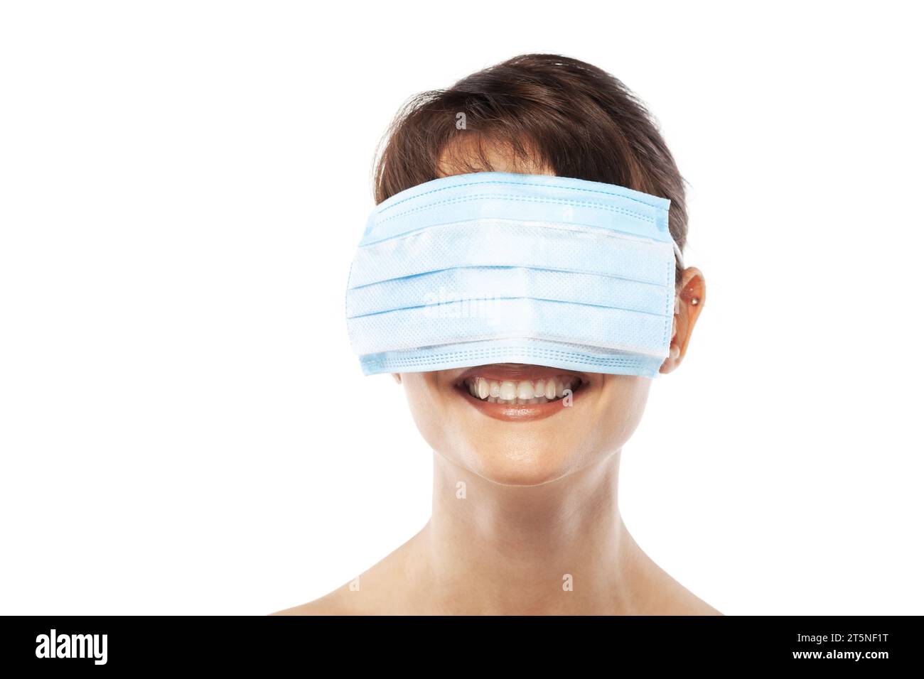 Portait of a happy girl smiling and wrongly wearing medical face mask ...