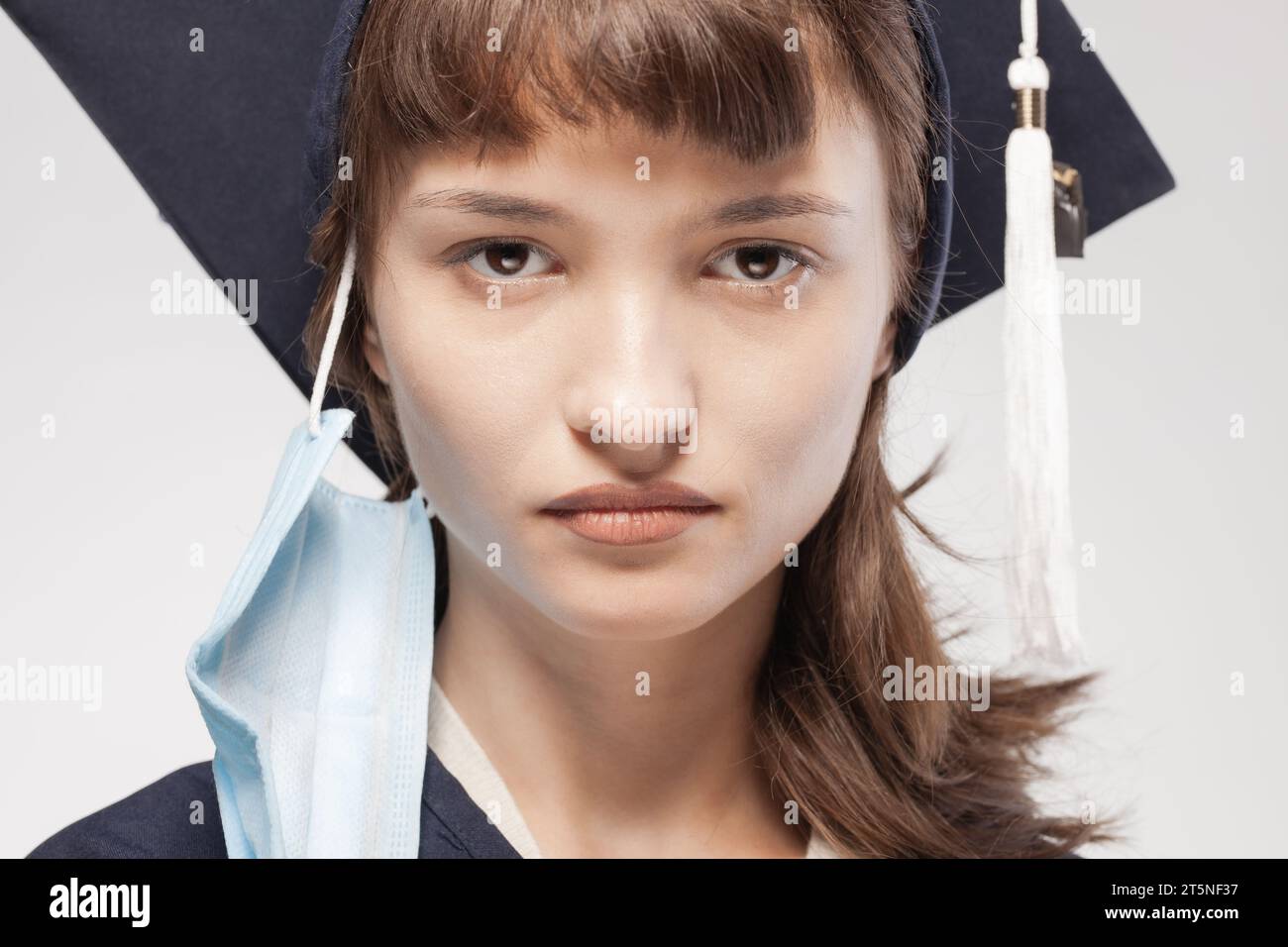 Graduation girl wearing gown and cap. Female student wearing protective ...