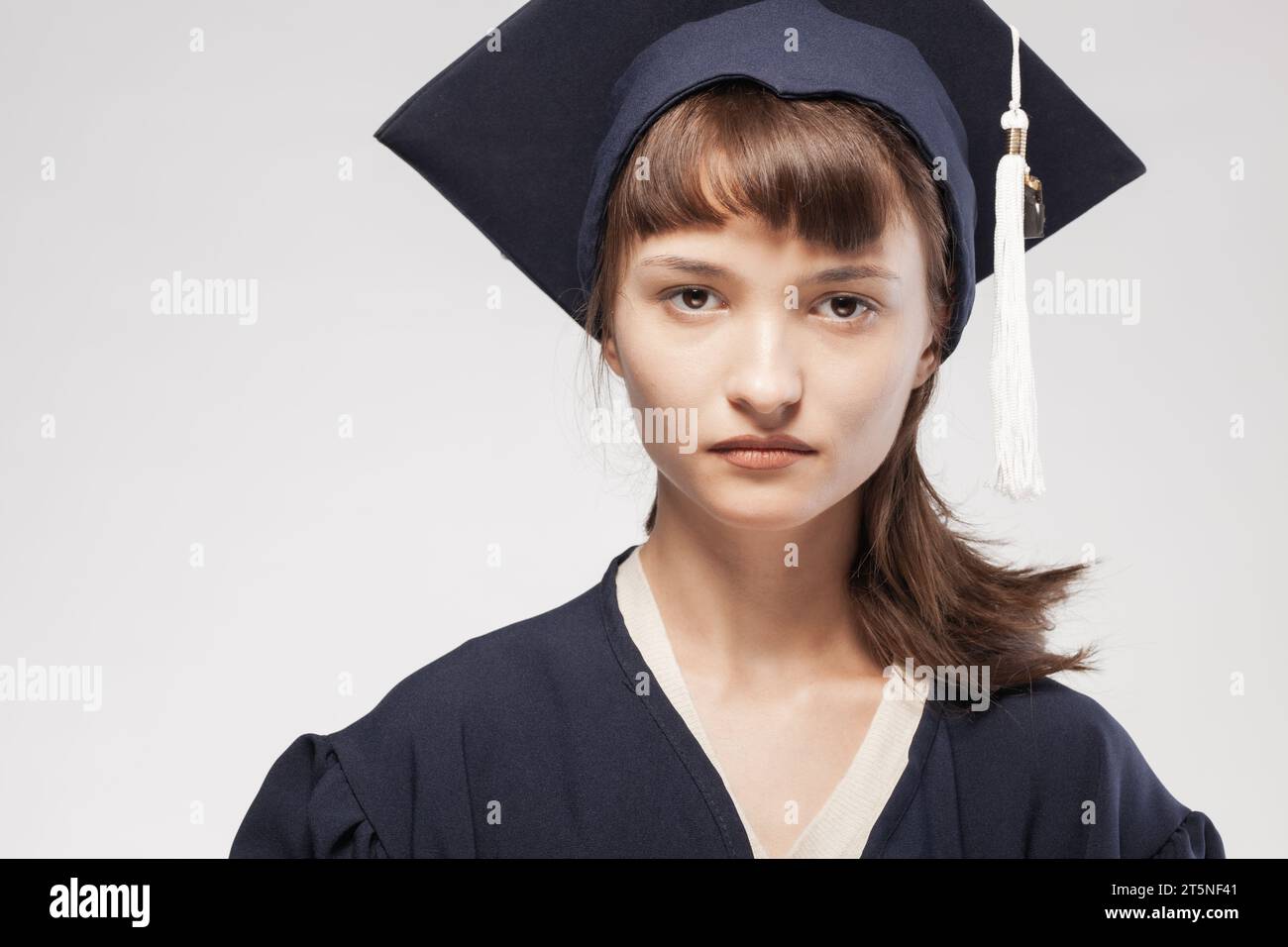 Graduation student portrait isolated on white background. Serious girl ...
