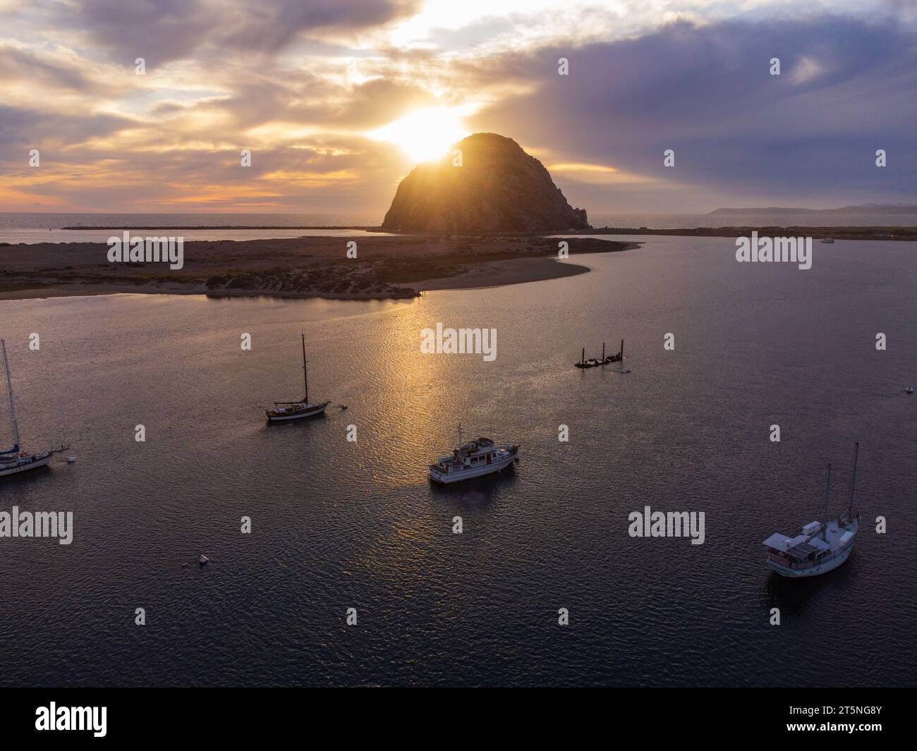 The rock of Morro Bay, California, USA at sunset, with sea lions and ...