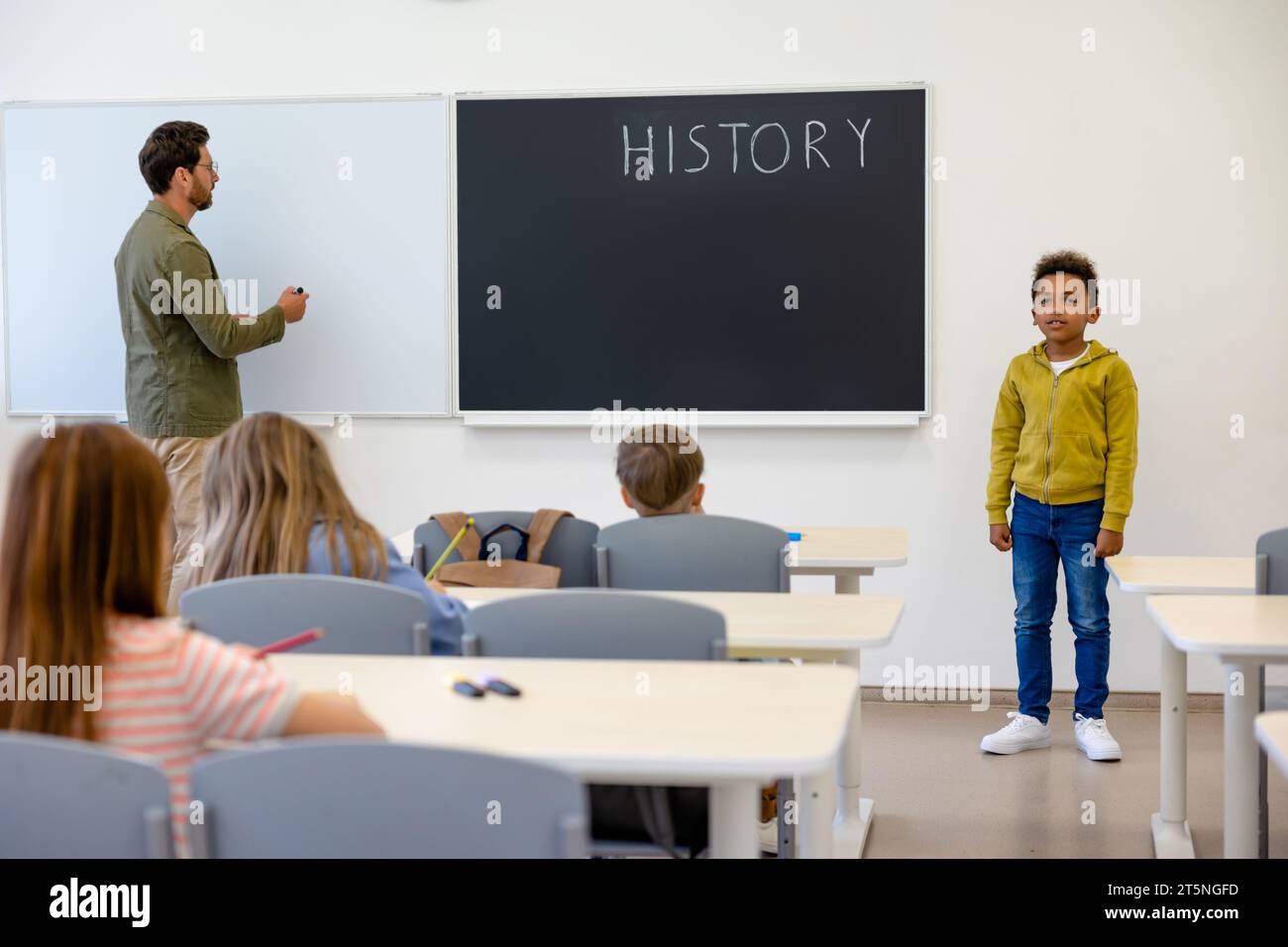 Teacher introducing a new boy to the classmates Stock Photo - Alamy