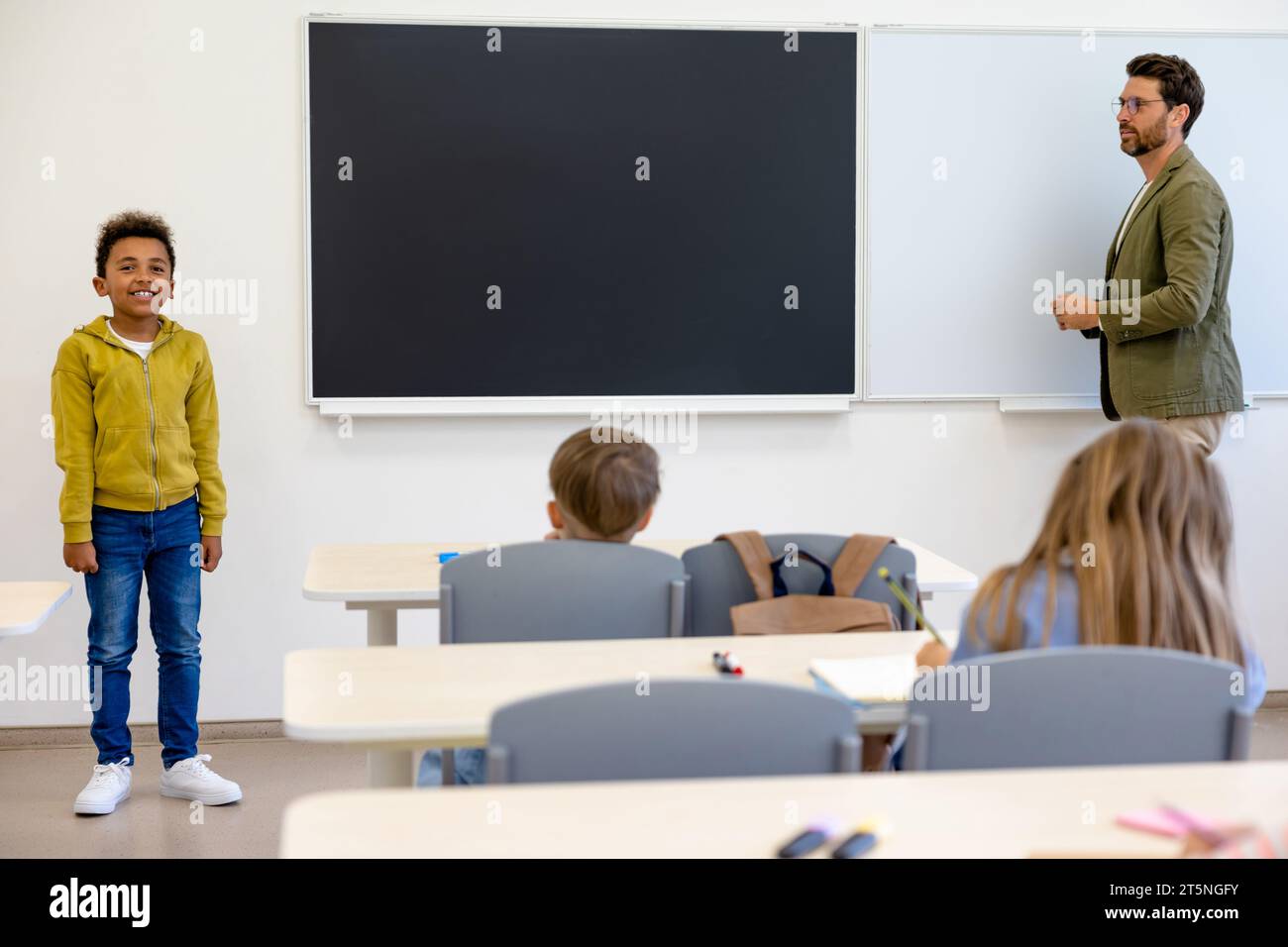 Teacher introducing a new boy to the classmates Stock Photo - Alamy