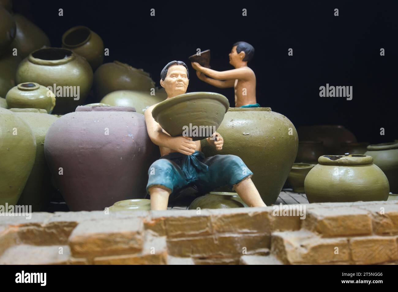 A diorama showing workers busy firing clay pots, vases. At the local ...