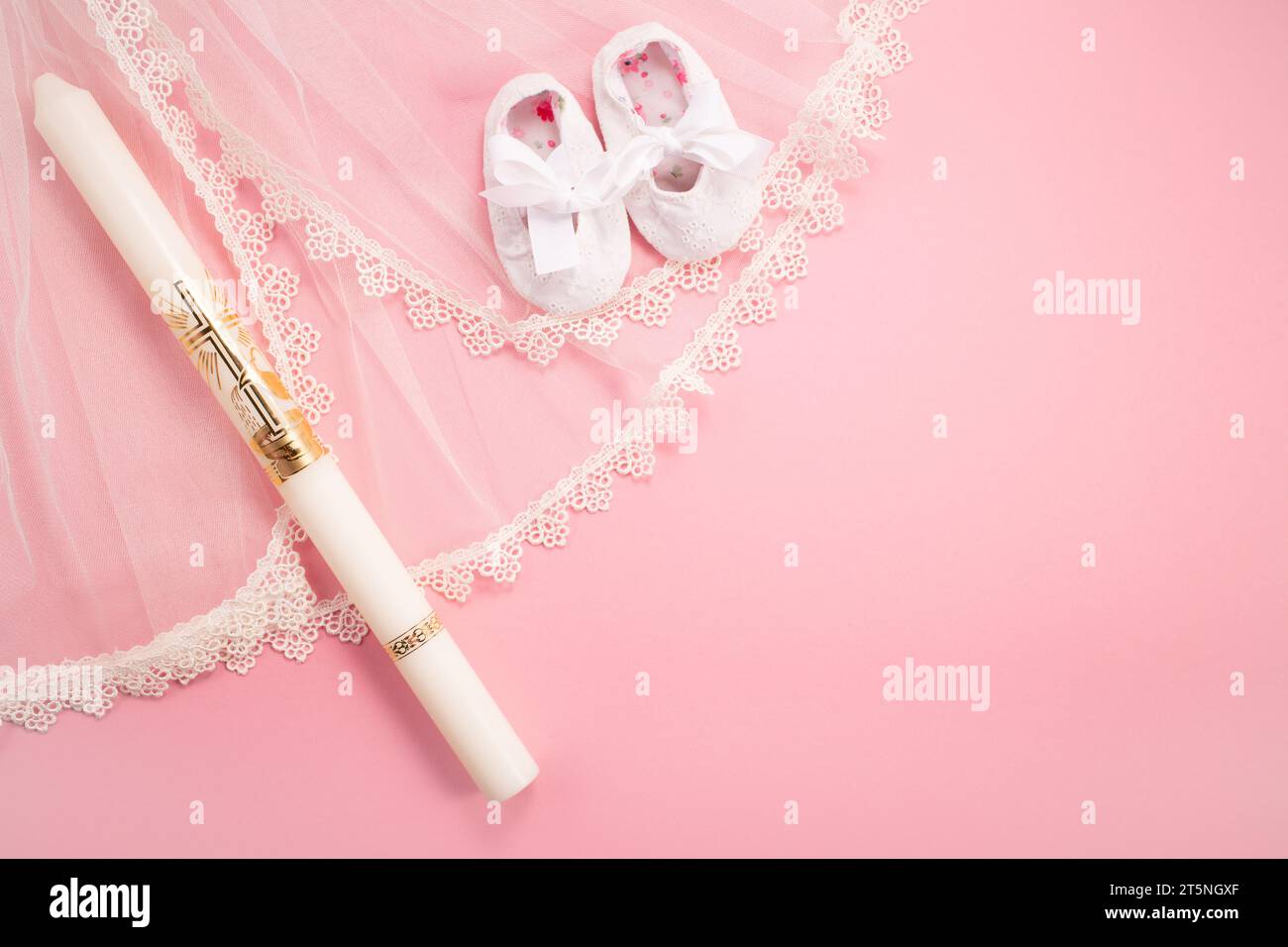 Christening background with baptism baby shoes, dress and candle on ...