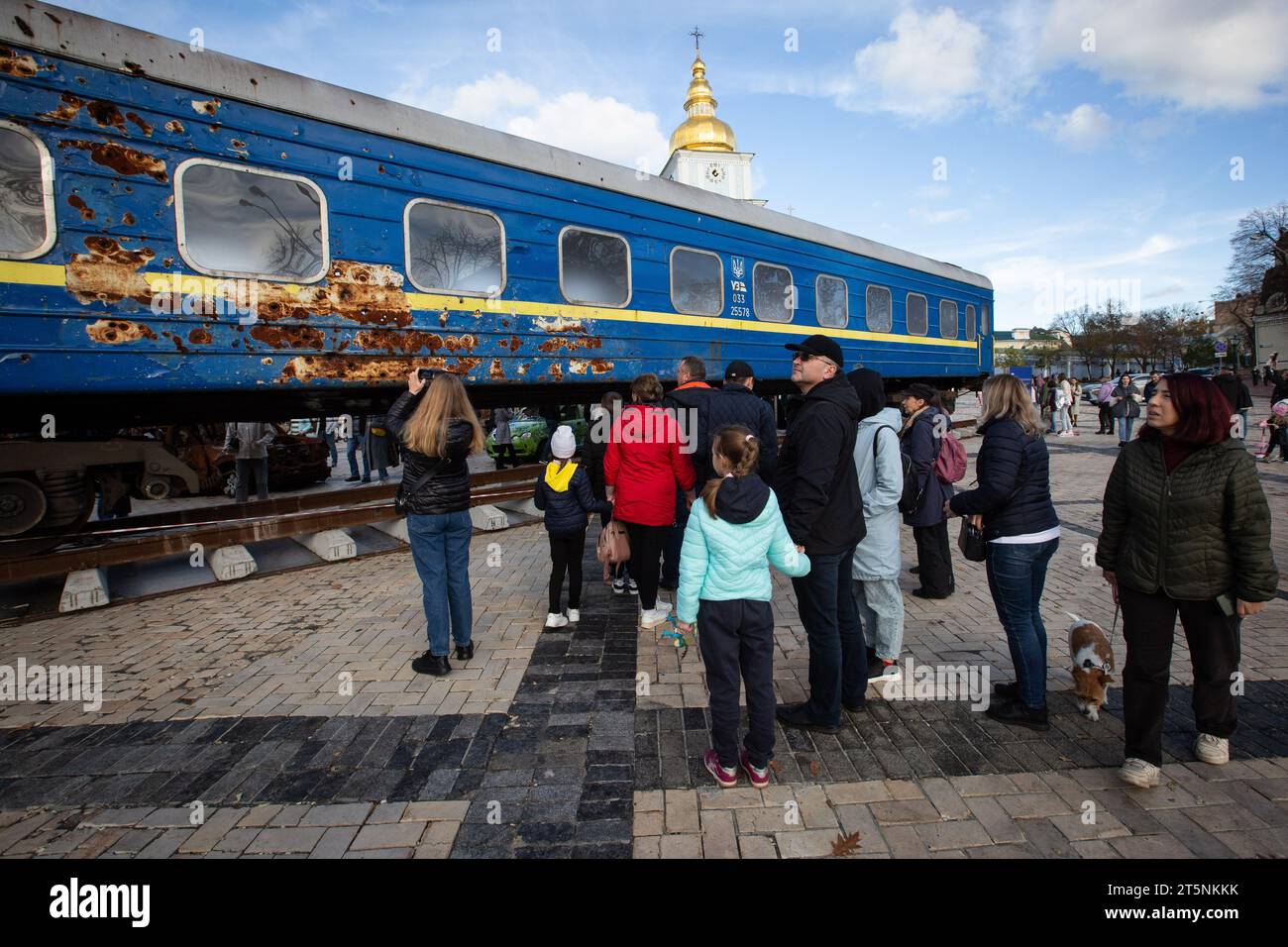 People look at a destroyed railway carriage used to evacuate people ...