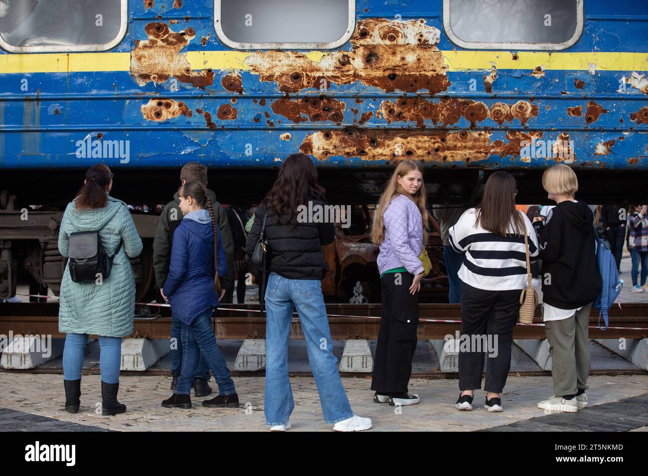 People look at a destroyed railway carriage used to evacuate people ...
