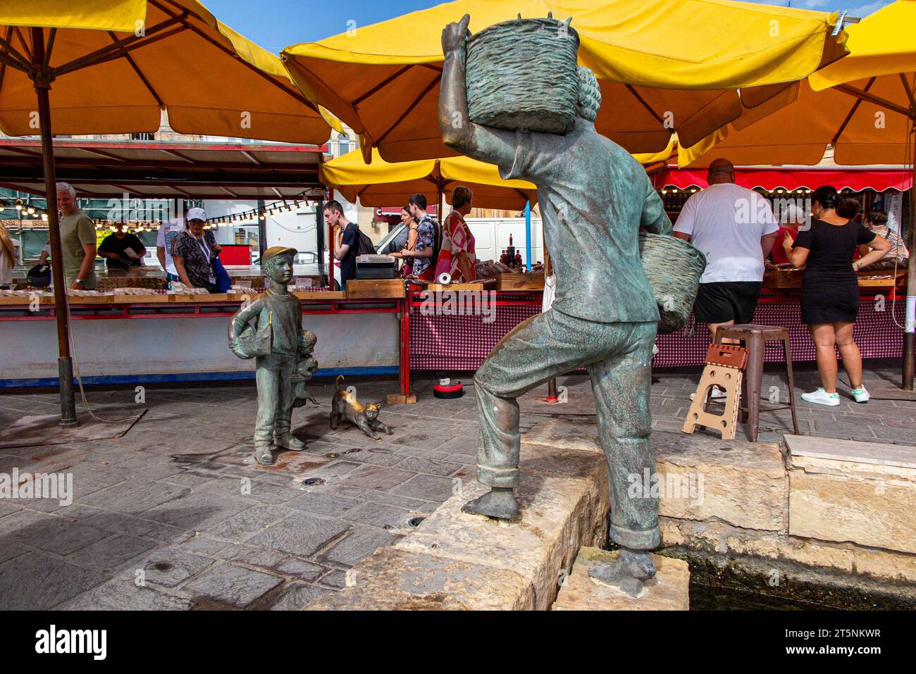 Statues of a fisherman, a boy and a small cat in Marsaxlokk Harbour and ...