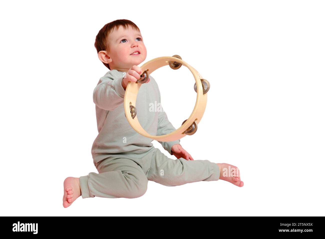 Happy toddler baby with a musical instrument tambourine on a studio ...