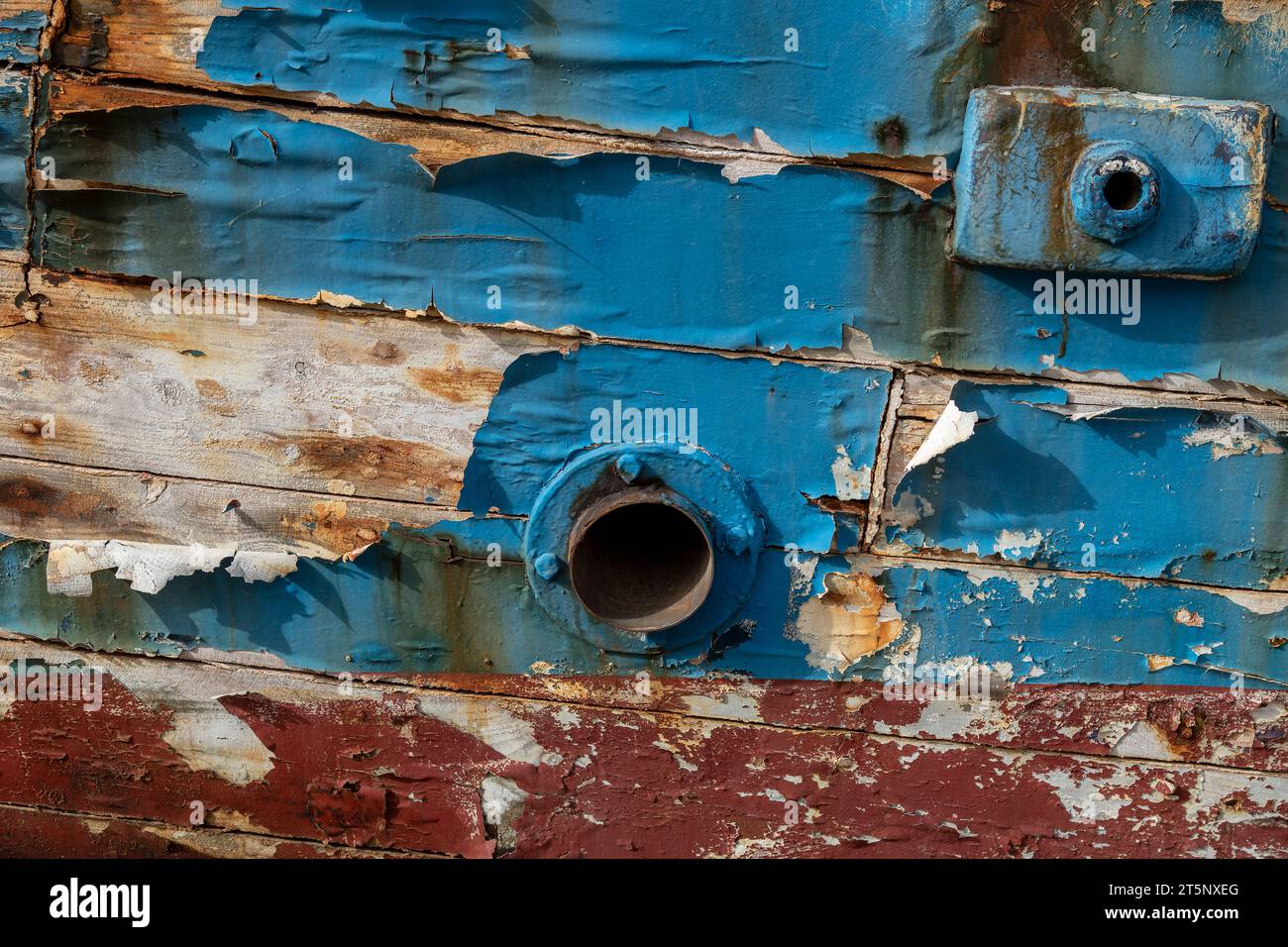 shabby chic or distressed old planked wooden boat with rusty scupper ...