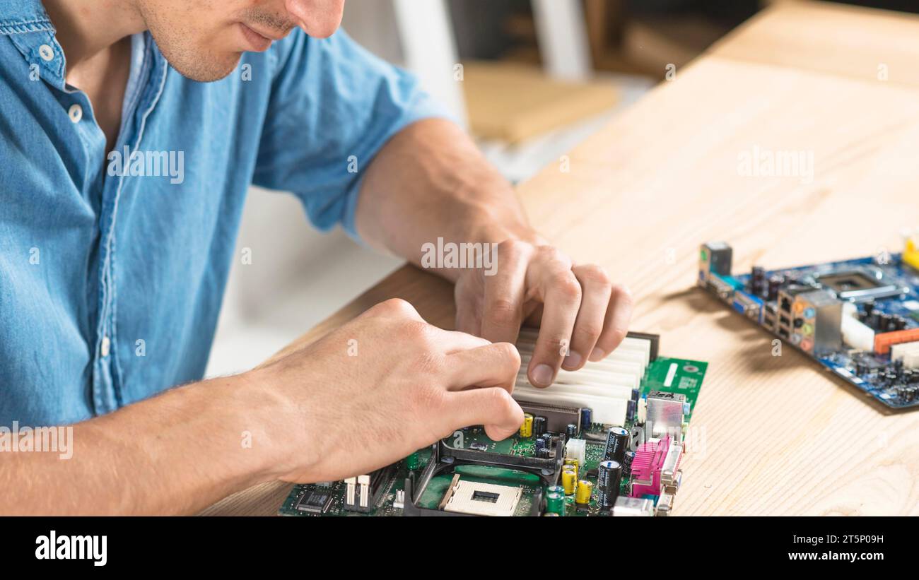 Close up male technician assembling motherboard Stock Photo - Alamy