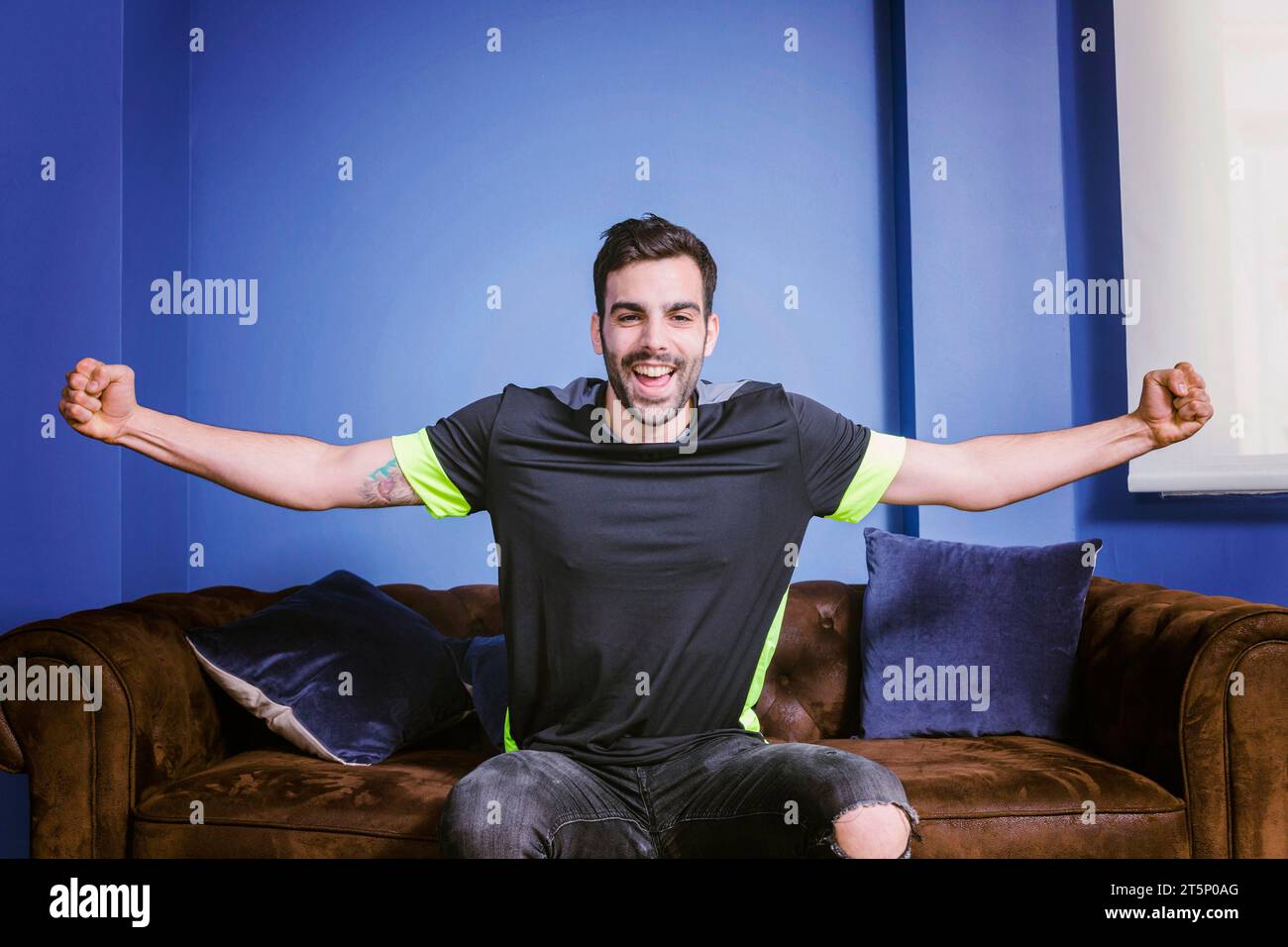 Happy football fan couch Stock Photo - Alamy