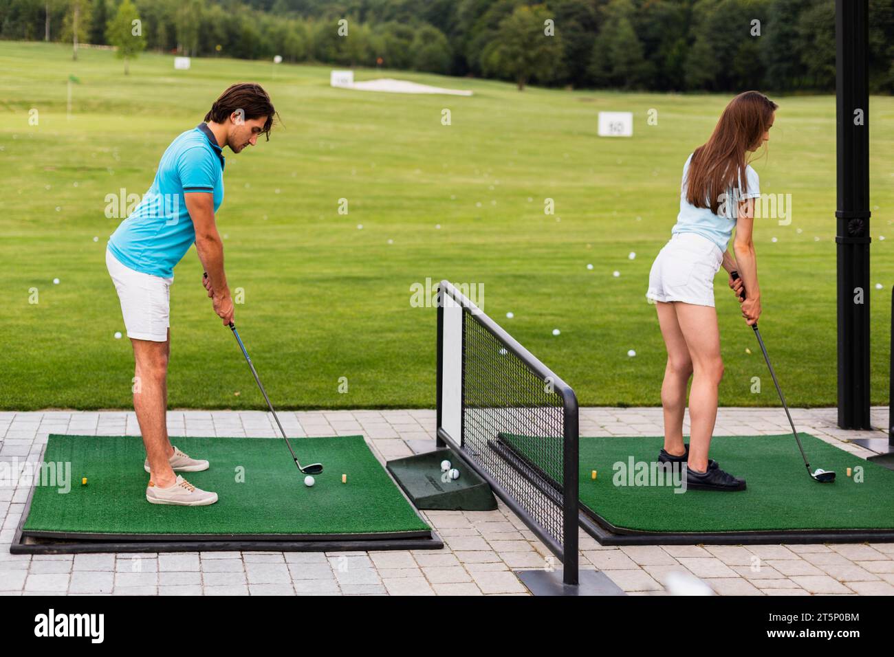 Back view golf players practicing swing Stock Photo - Alamy