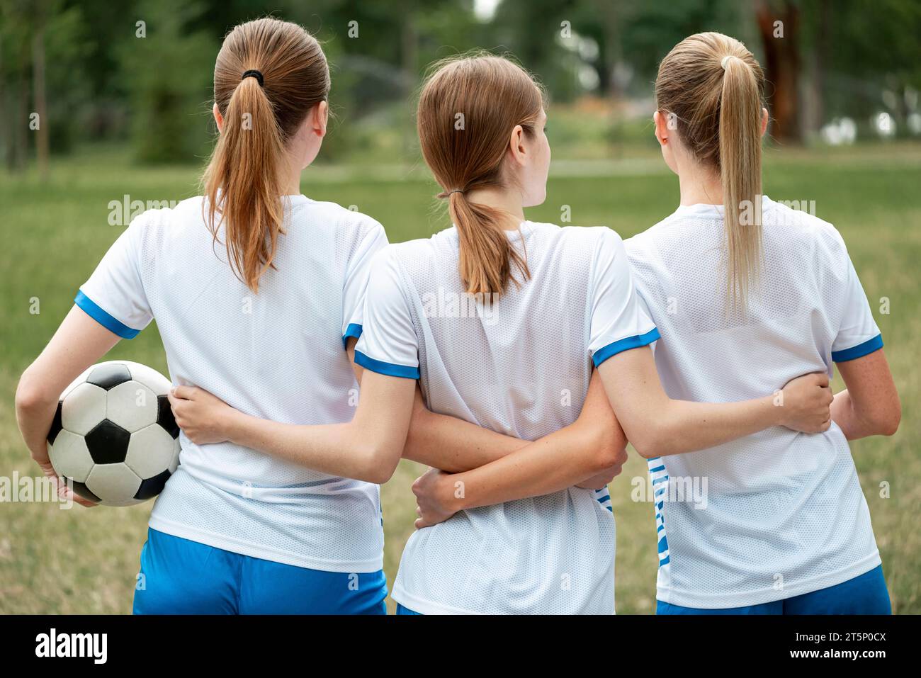 Back view women holding each other Stock Photo - Alamy