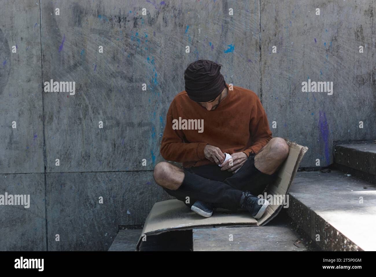 Homeless man sitting cardboard outdoors Stock Photo - Alamy