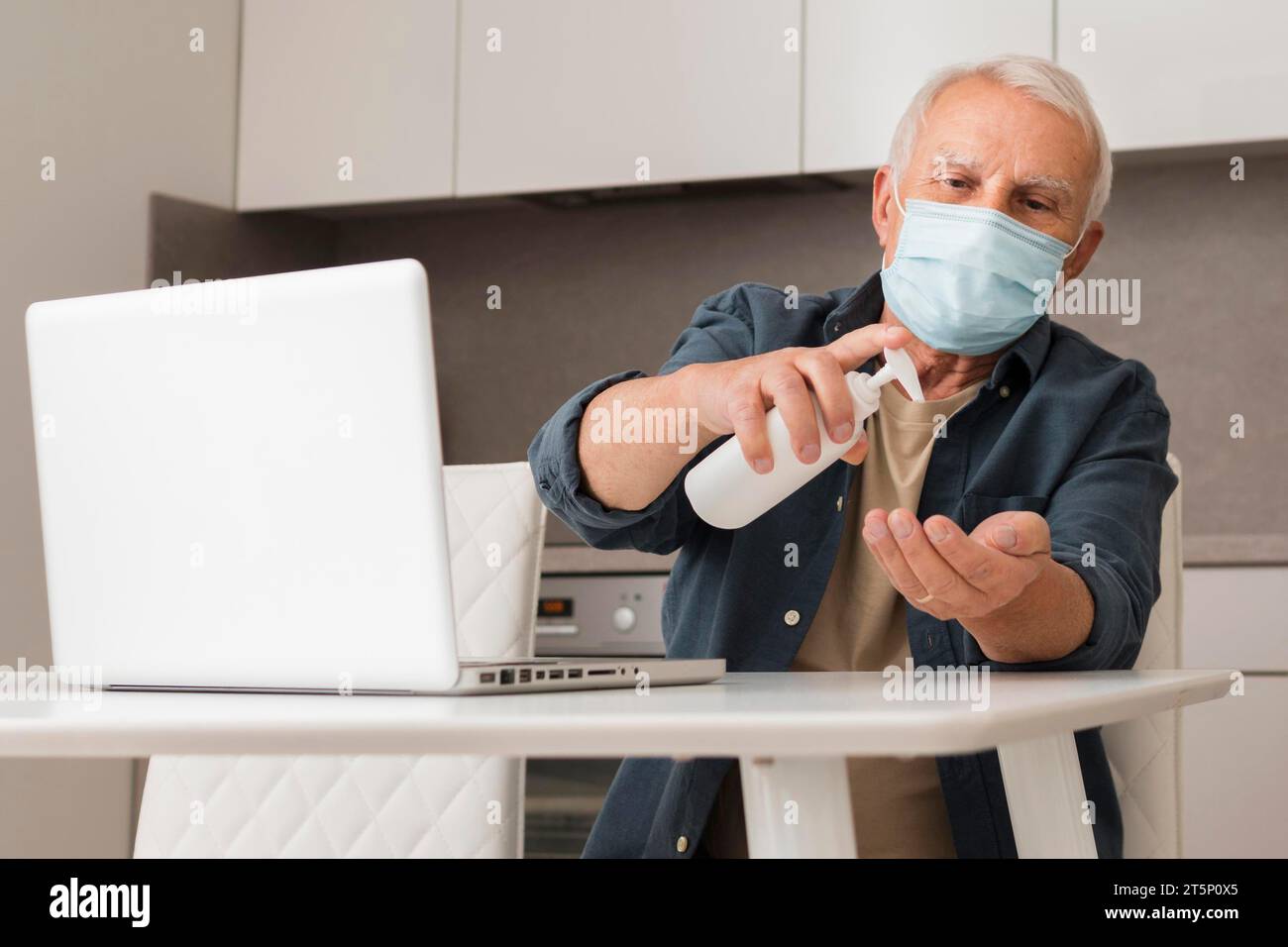 Medium shot old man using disinfectant Stock Photo - Alamy