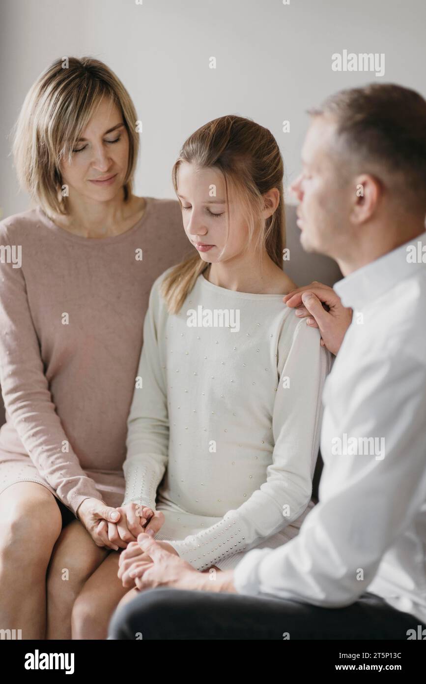 Parents daughter praying together home Stock Photo - Alamy