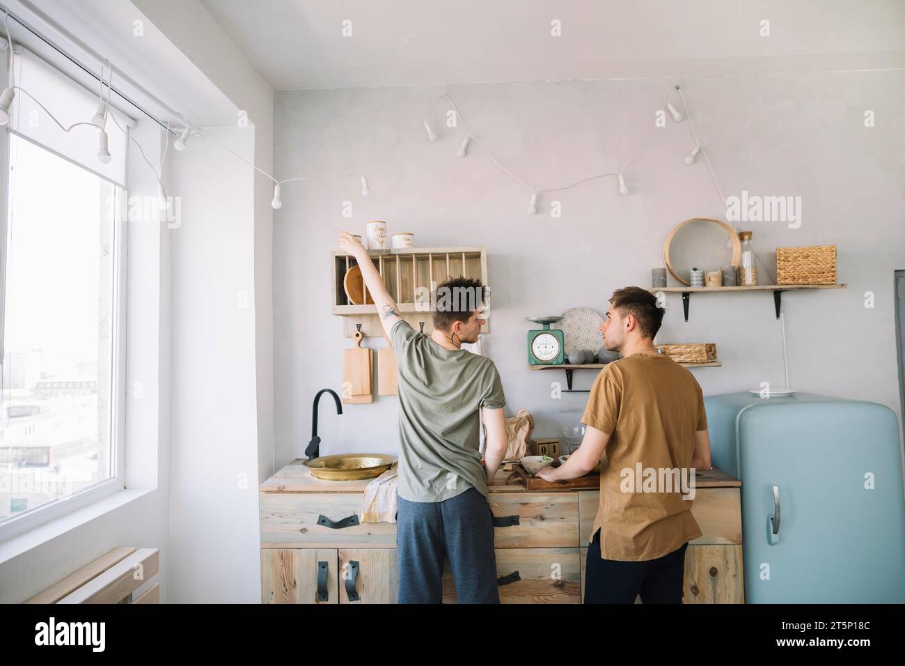 Two friends prepare meal together hi-res stock photography and images ...