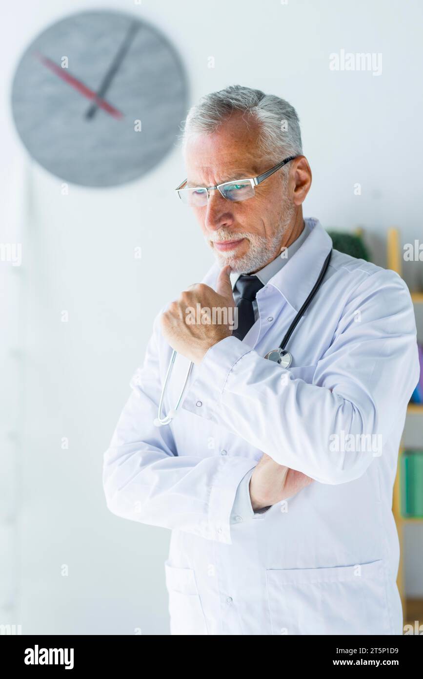 Senior medical practitioner thinking office Stock Photo - Alamy