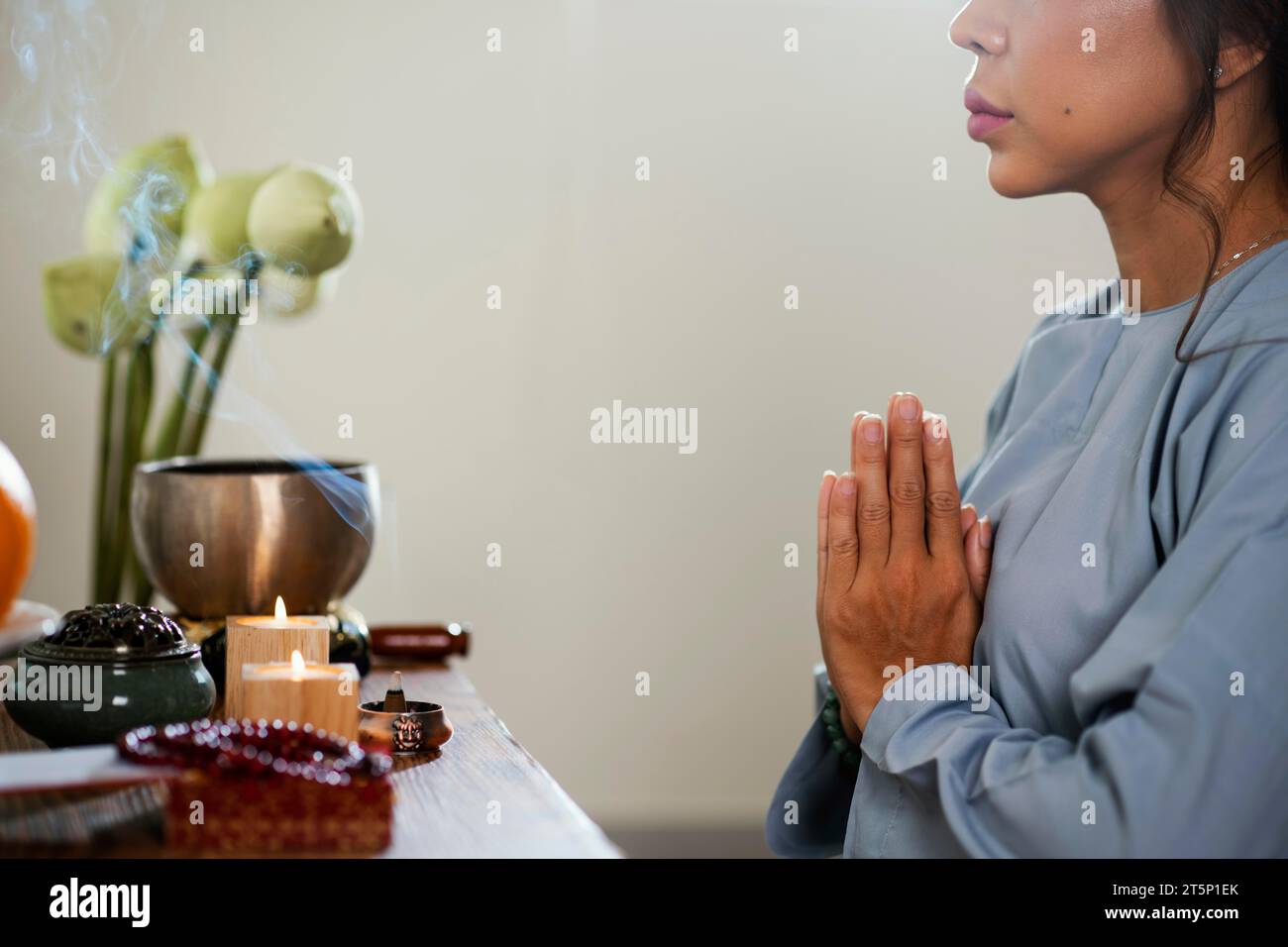 Side view woman praying front candles Stock Photo - Alamy