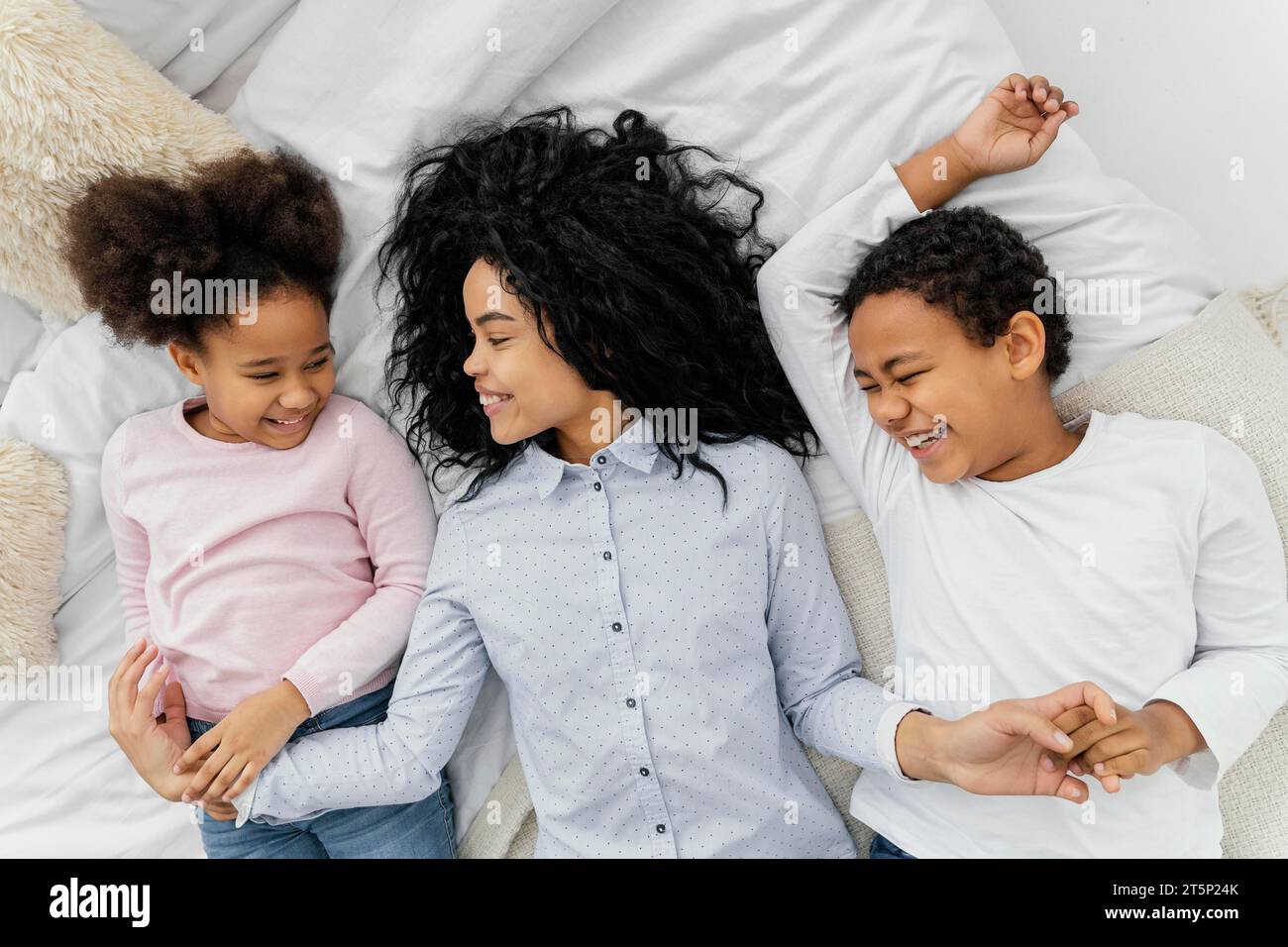 Top view smiley mother staying bed home with her children Stock Photo ...