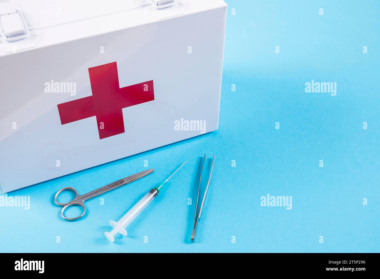 White first aid kit with scissor syringe tweezers blue background Stock ...