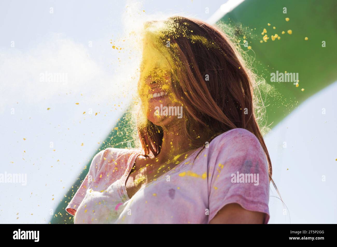 Yellow holi color powder explodes woman s face Stock Photo - Alamy