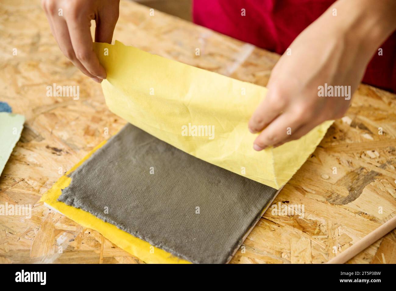 Close up woman s hand holding yellow fabric paper pulp Stock Photo - Alamy