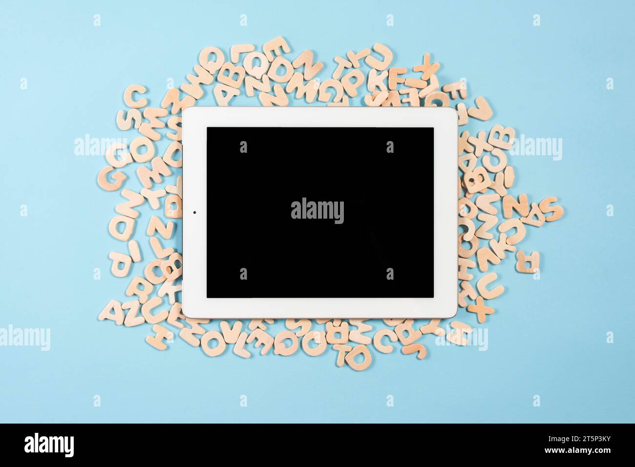 Digital tablet with black display screen multiple wooden letters ...