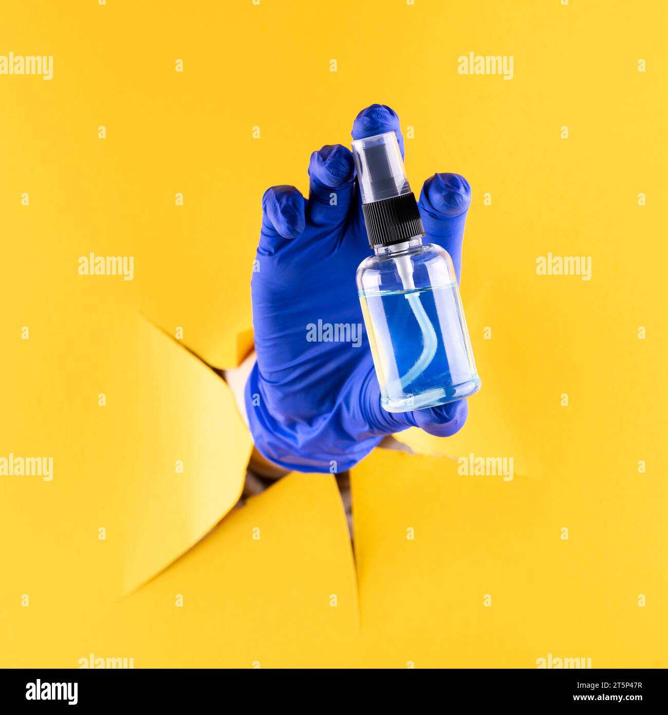 Front view hand with surgical glove holding hand sanitizer bottle Stock ...