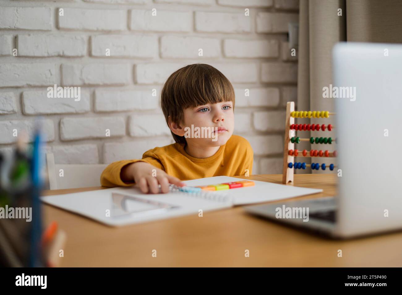 Front view child desk learning from laptop Stock Photo - Alamy