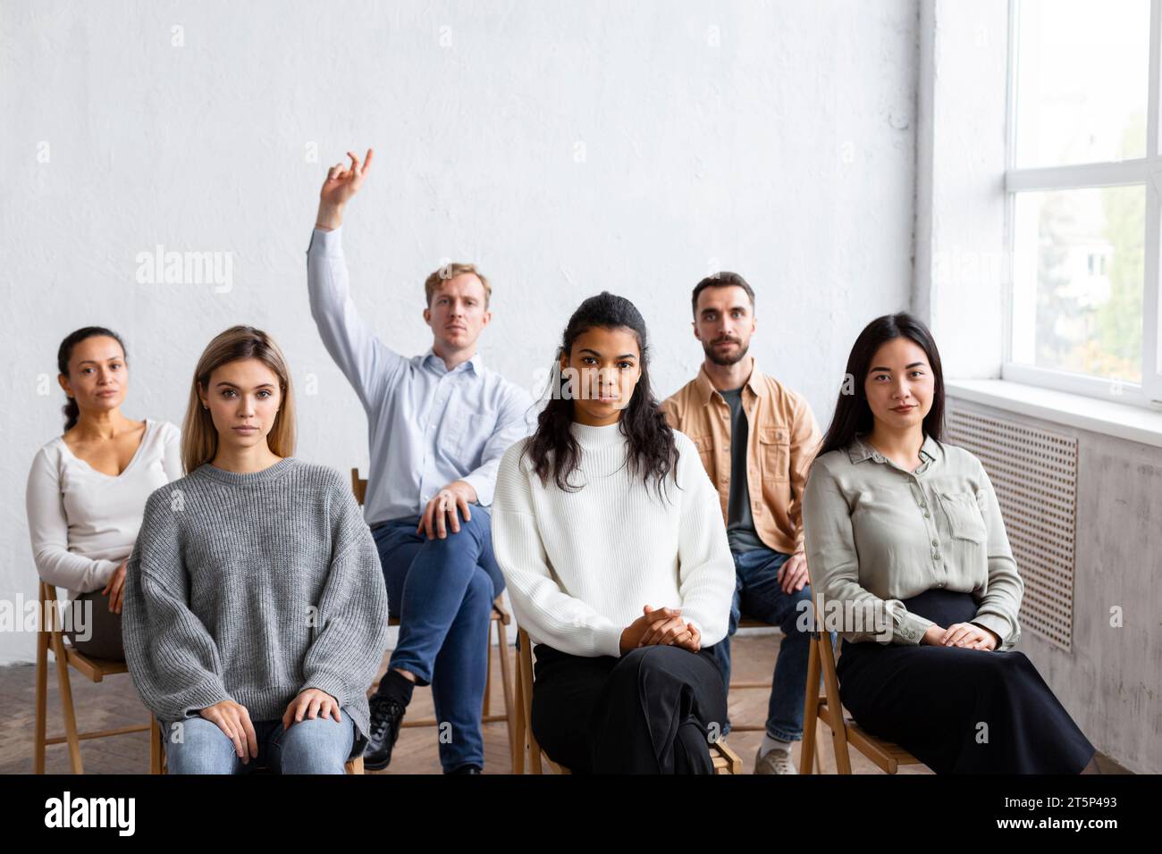 Front view man raising hand question group therapy session Stock Photo ...