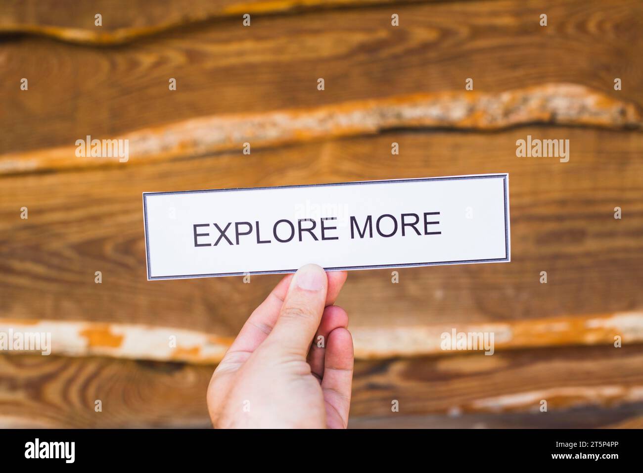 Human hand holding paper with explore more text Stock Photo - Alamy