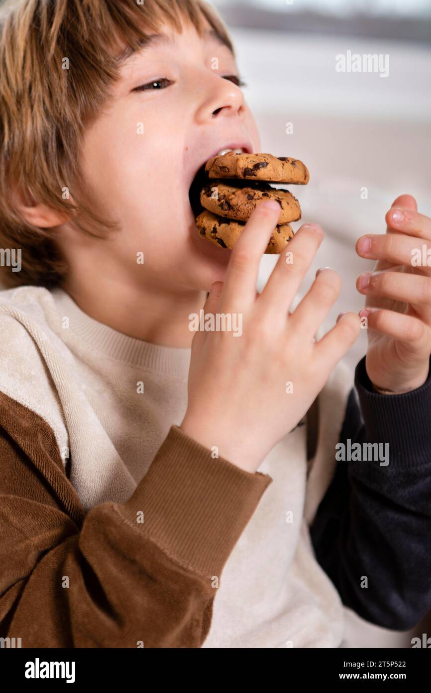 Kid eating cookies home Stock Photo - Alamy