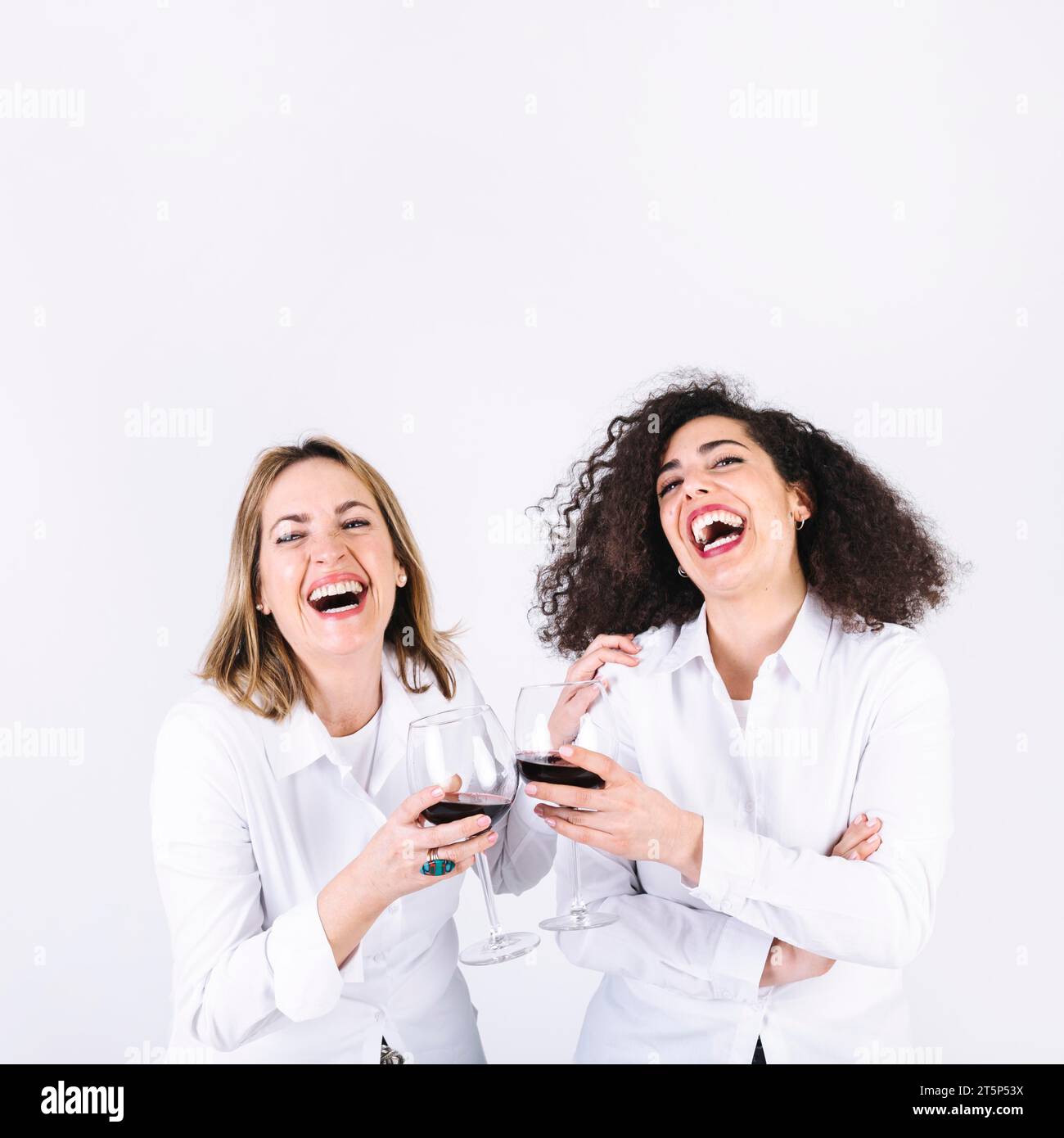 Laughing women clinking glasses Stock Photo - Alamy