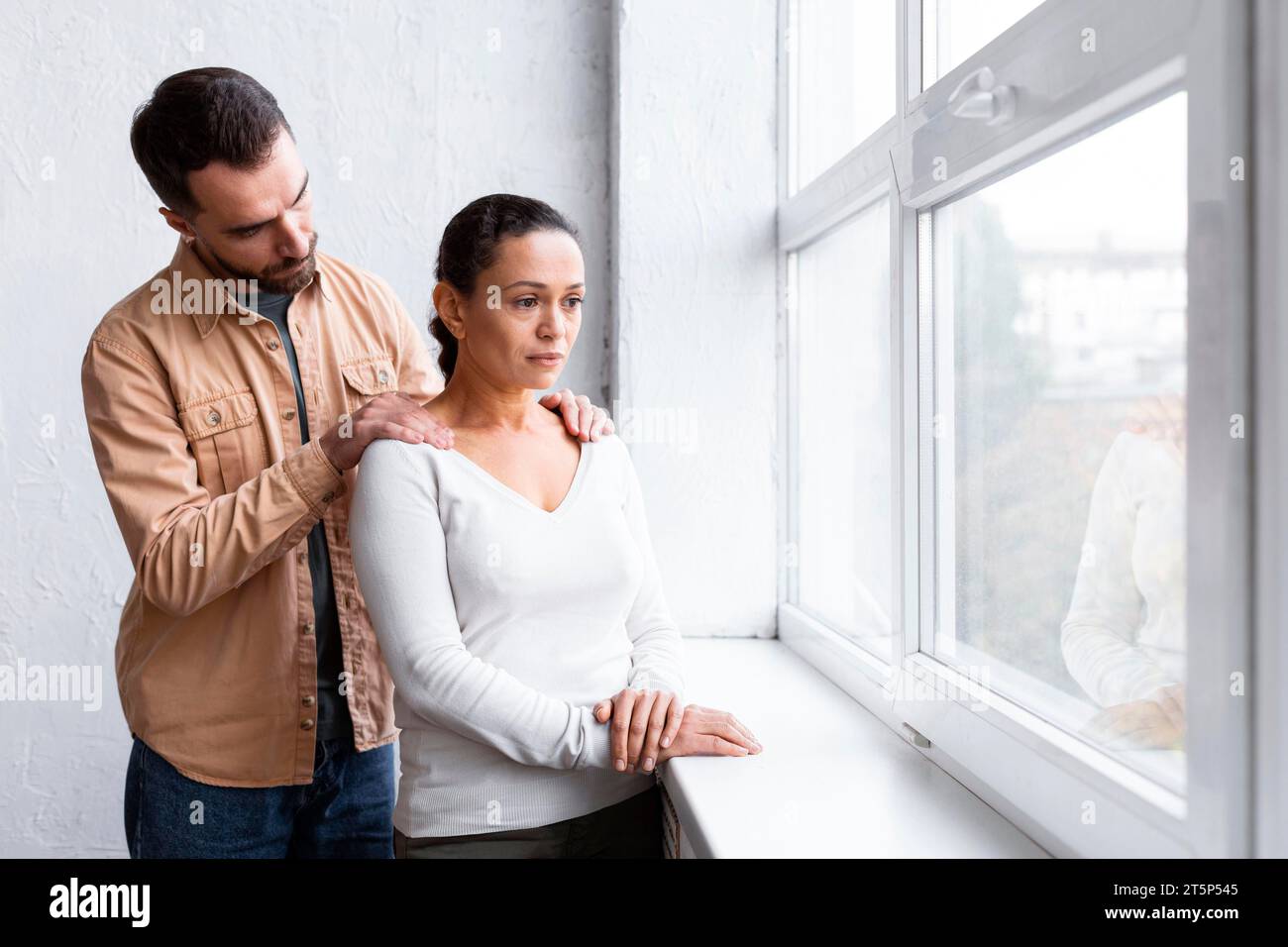 Man consoling sad woman group therapy session while looking through ...