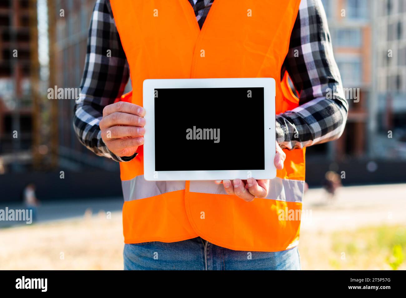 Medium shot construction engineer holding tablet Stock Photo - Alamy