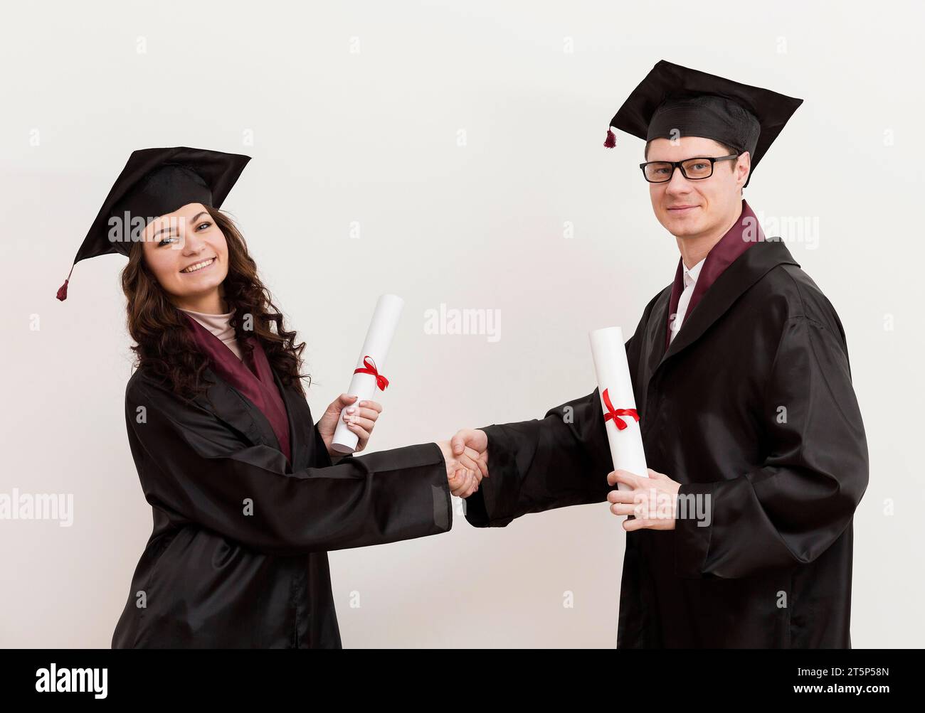 Medium shot graduates shaking hands Stock Photo - Alamy