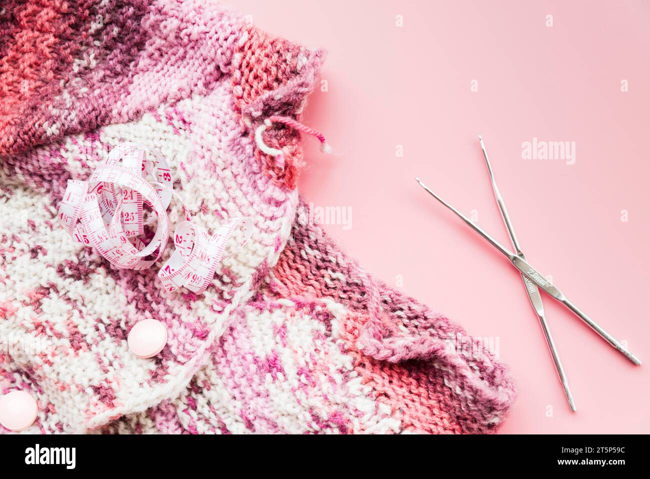 Measuring tape with knitting crochet needles pink backdrop Stock Photo ...