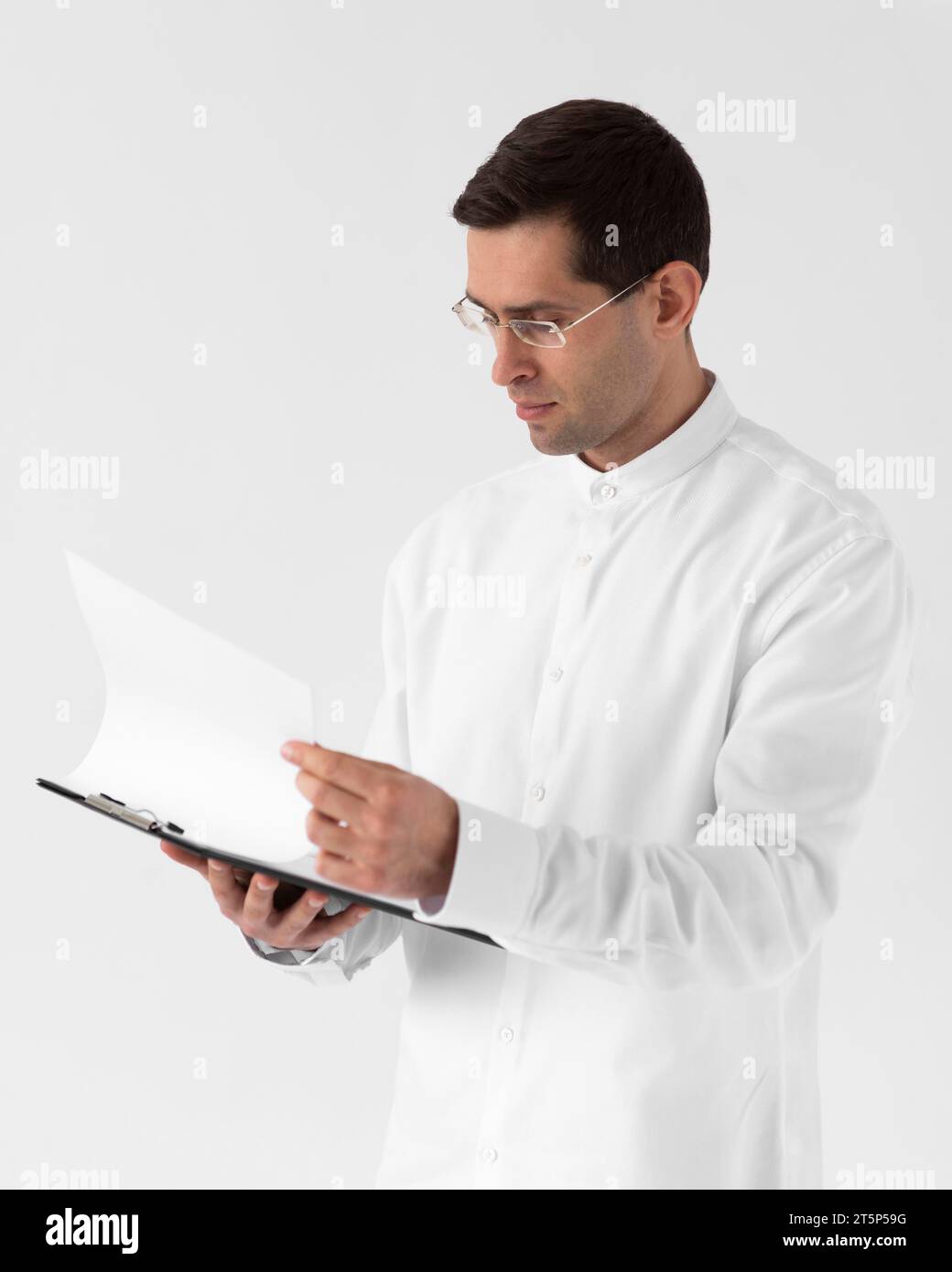 Medium shot man reading document Stock Photo - Alamy