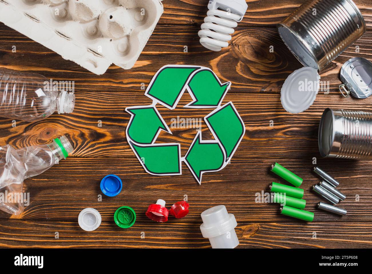 Recycle symbol surrounded with waste items brown wooden textured ...